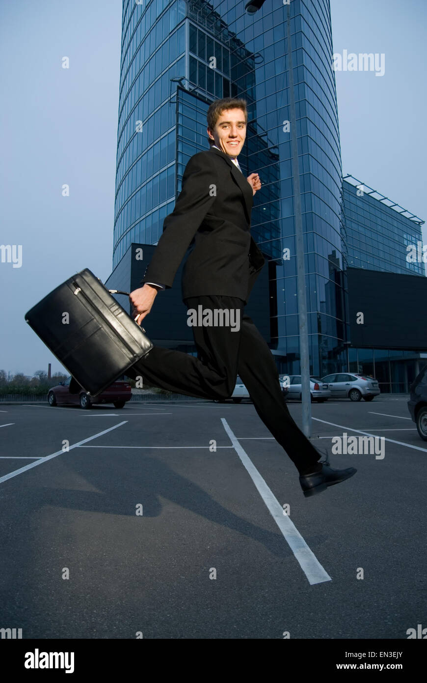 Happy business man running home after work Stock Photo - Alamy