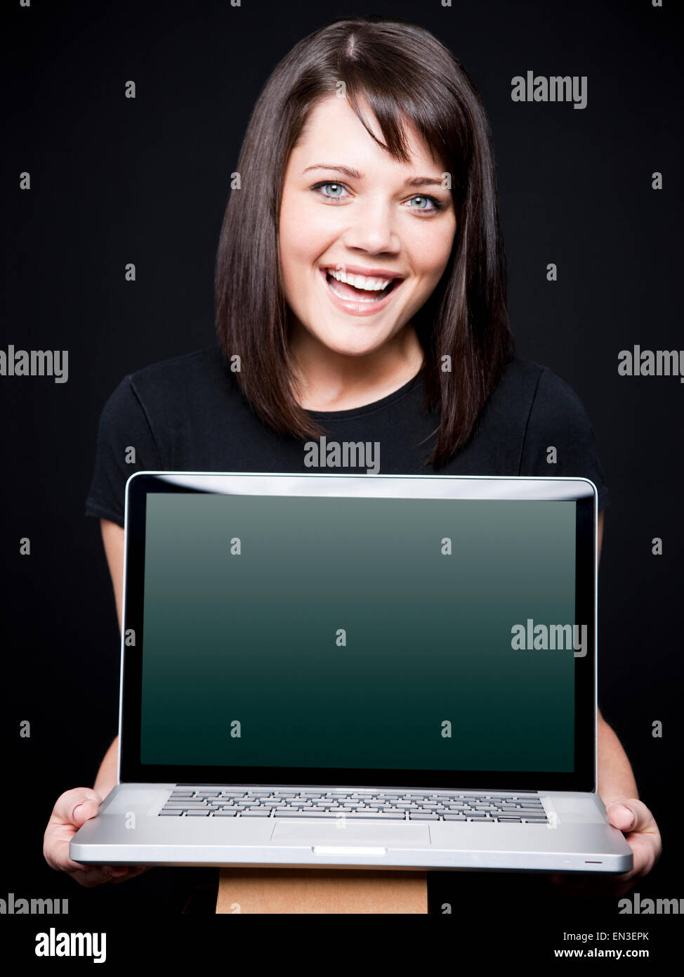 Studio portrait of woman holding laptop Stock Photo - Alamy