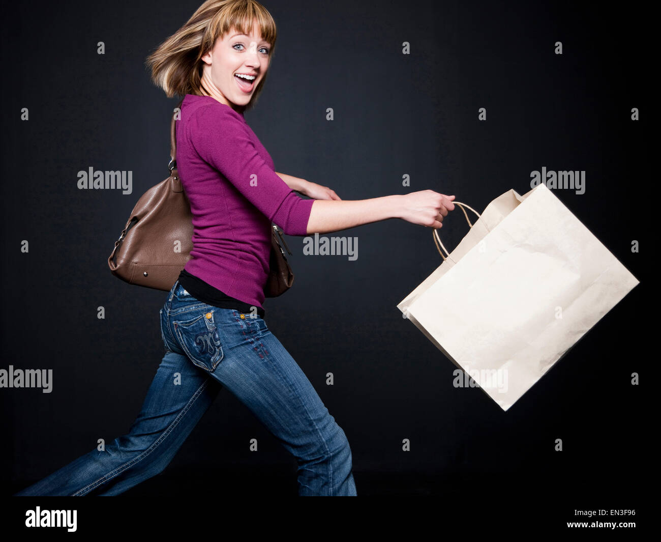 Young woman running with shopping bag Stock Photo - Alamy
