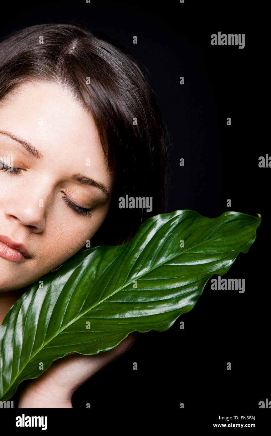 Young woman hugging leaf Stock Photo - Alamy