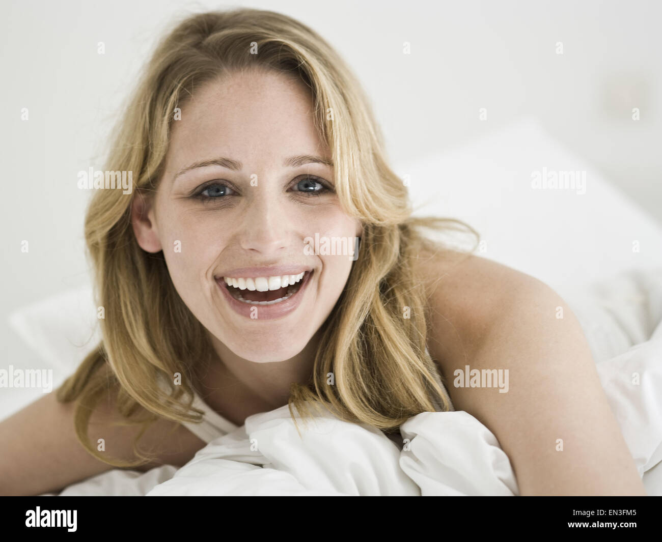 Closeup of woman in bed smiling Stock Photo - Alamy