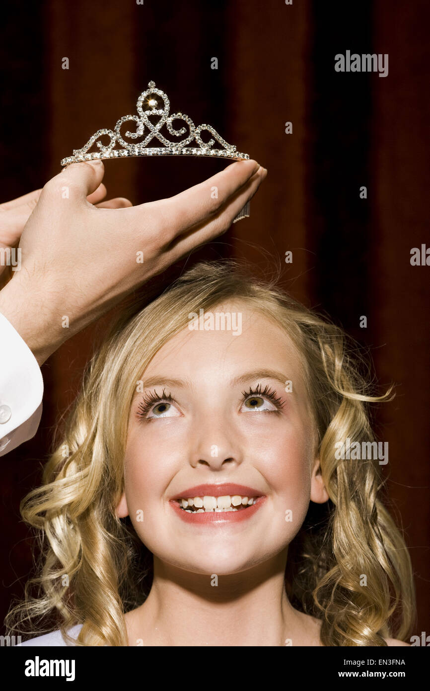 Man placing crown on girl's head Stock Photo - Alamy