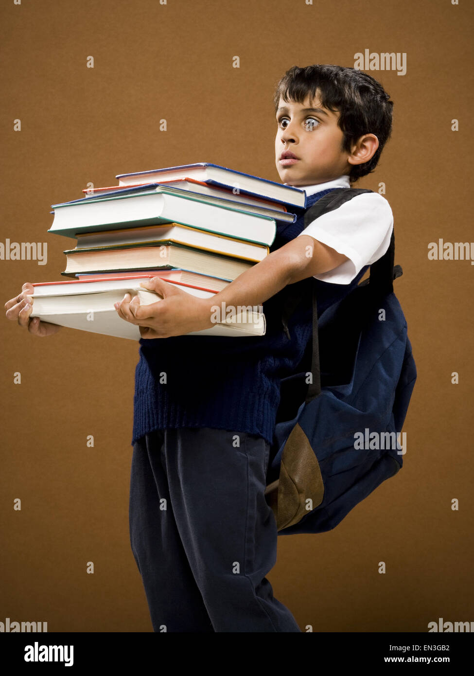 Boy with backpack holding pile of textbooks Stock Photo - Alamy
