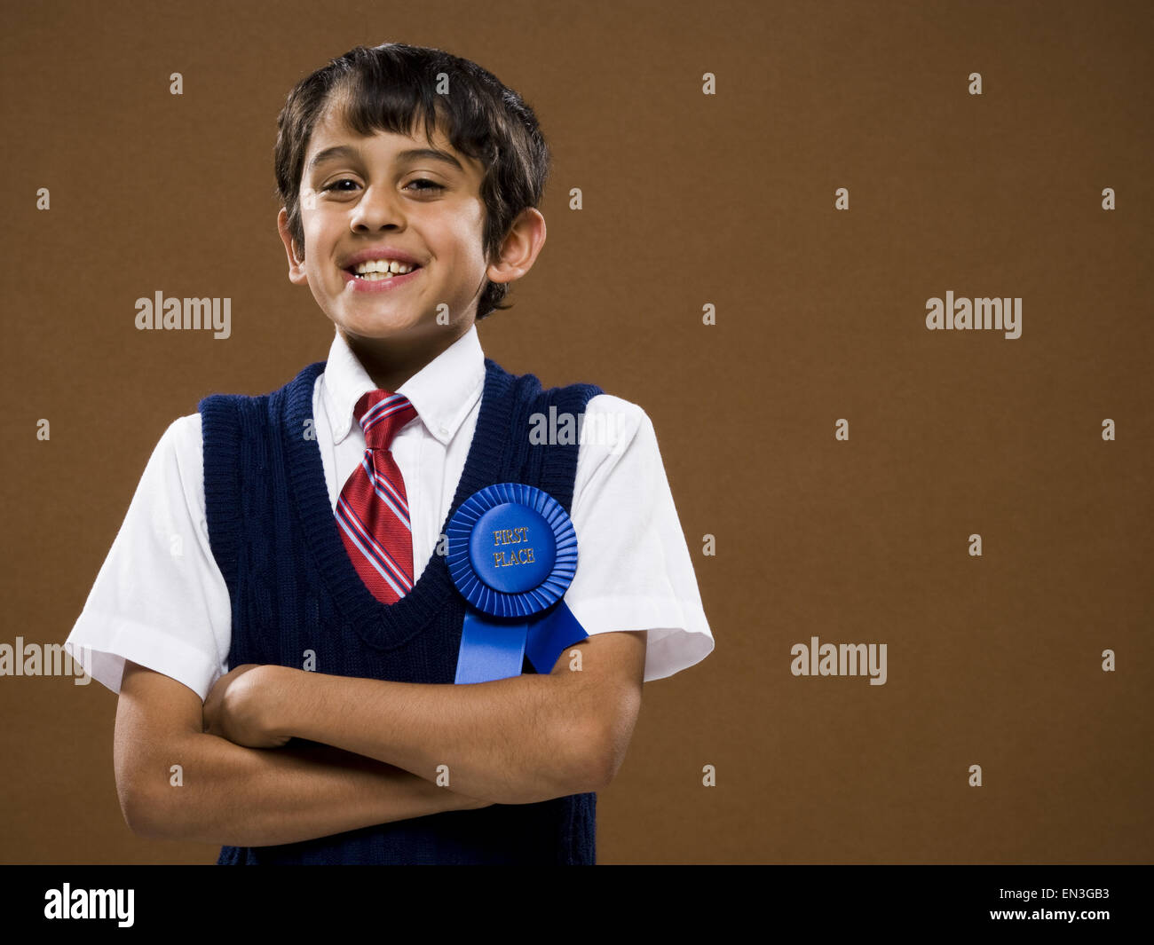 Boy with first place ribbon and arms crossed smiling Stock Photo - Alamy