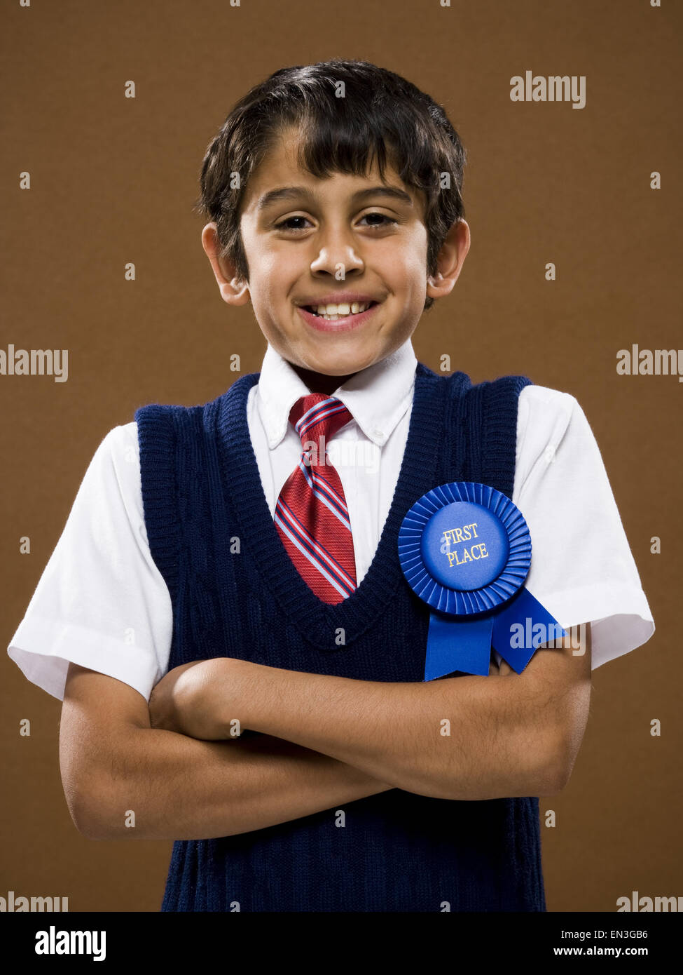 Boy with first place ribbon and arms crossed smiling Stock Photo - Alamy