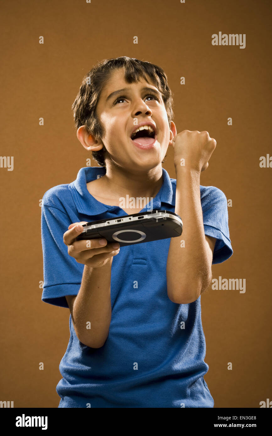 Boy holding video game cheering Stock Photo - Alamy