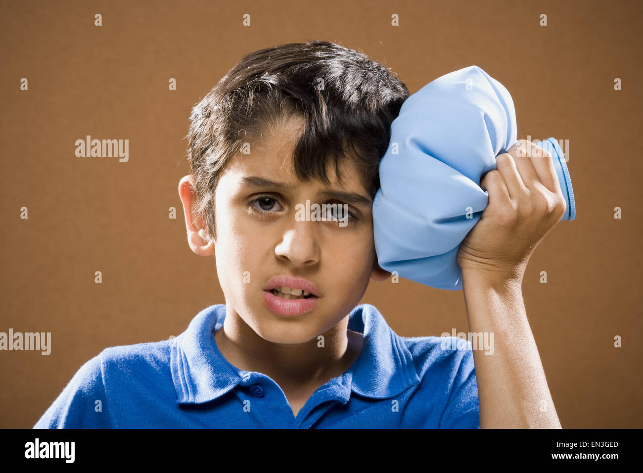 Boy holding ice pack to head Stock Photo - Alamy