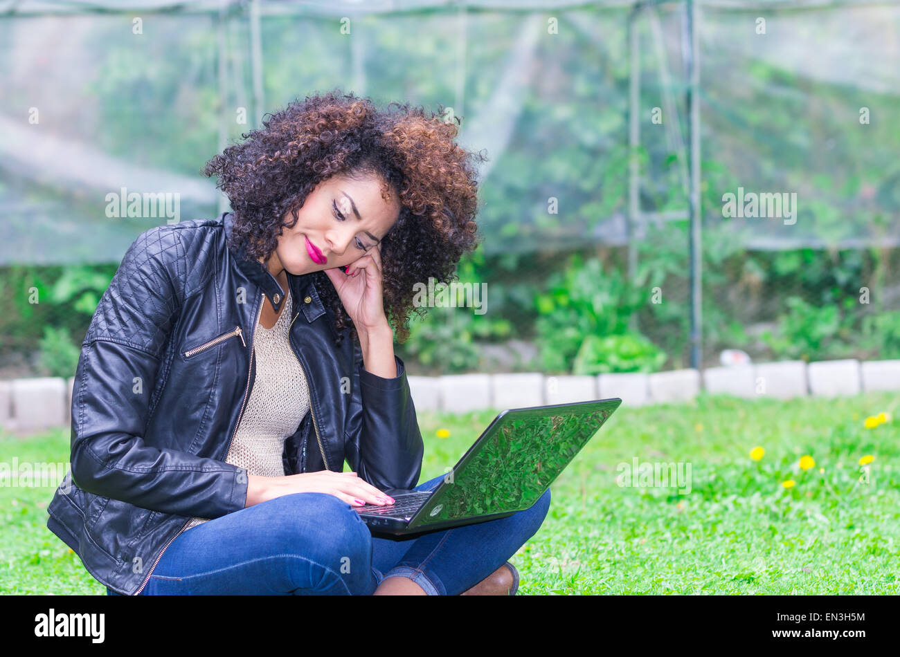 exotic beautiful young girl using laptop in the garden Stock Photo - Alamy