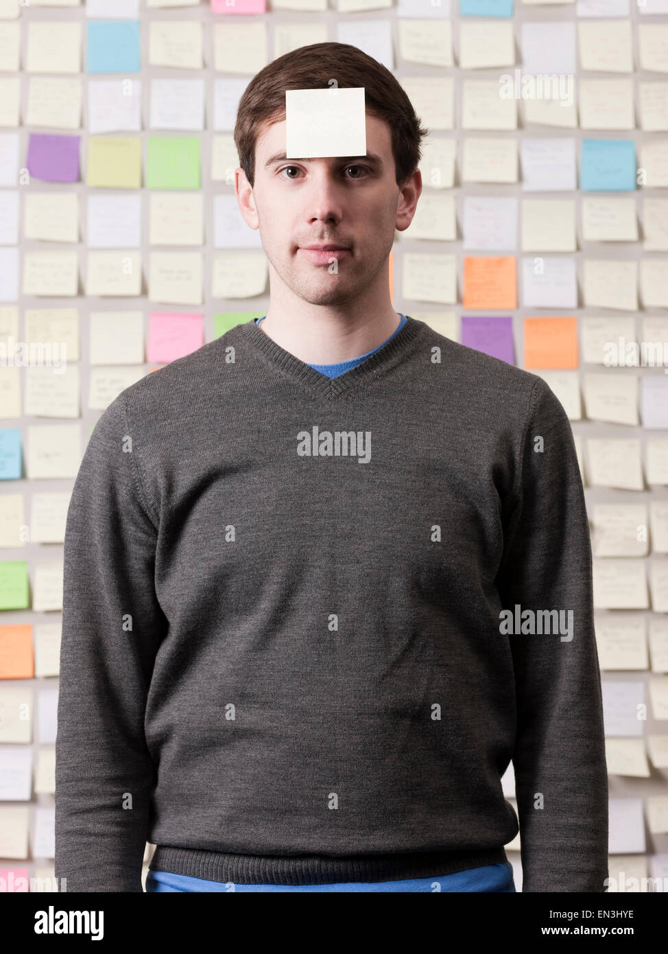 Studio shot of young man with post-it note on forehead Stock Photo - Alamy