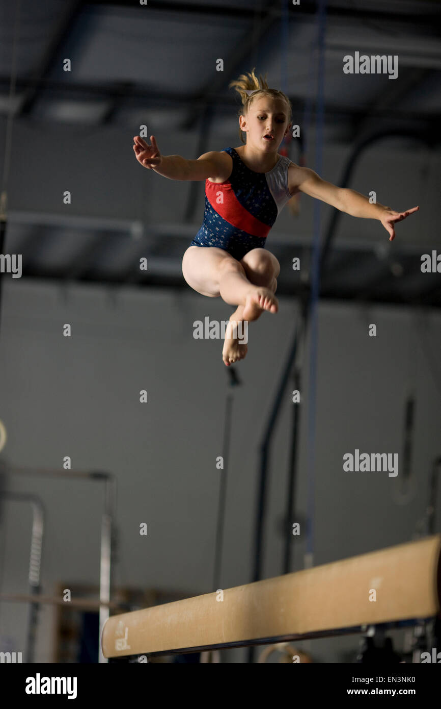 USA, Utah, Orem, girl gymnast (8-9) jumping on balance beam Stock Photo ...