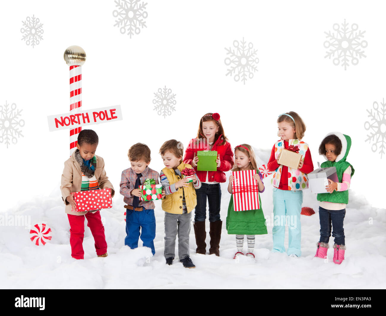Group of kids (18-23months, 2-3, 4-5, 6-7) standing next to North Pole ...