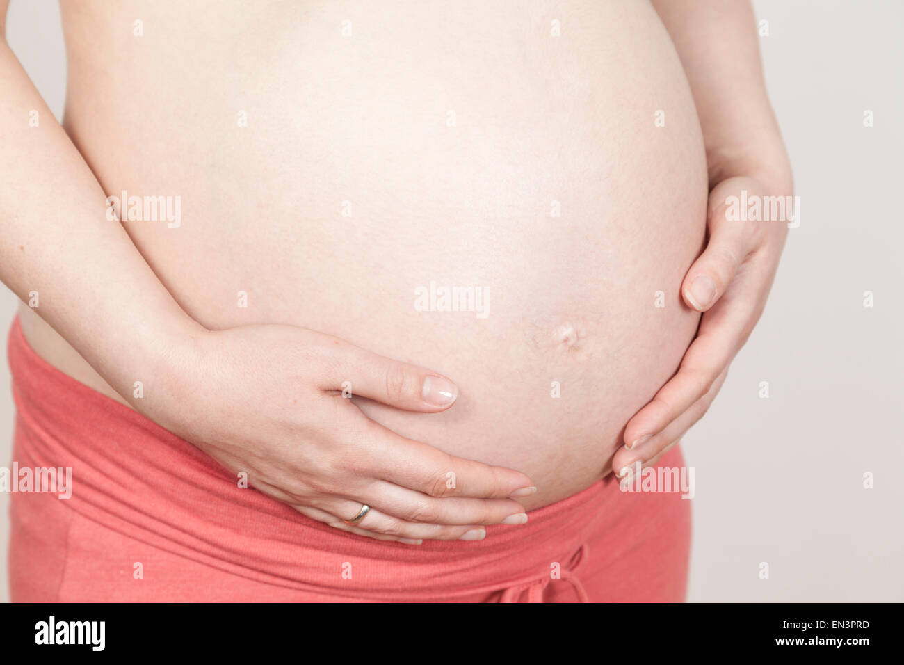 Pregnant touching belly Stock Photo - Alamy