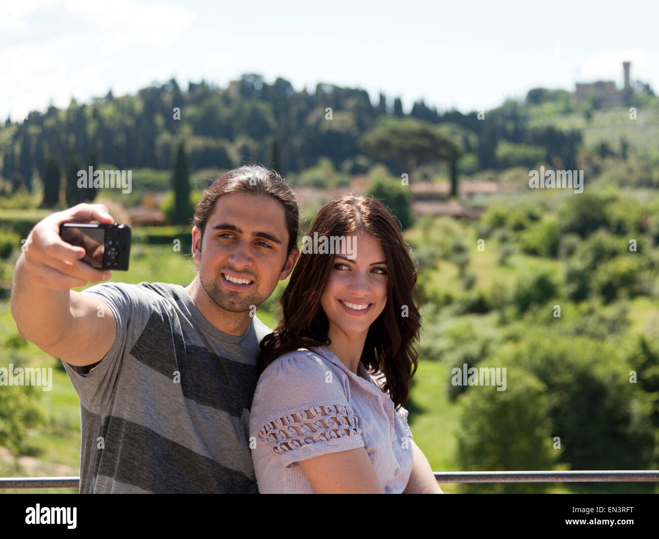 Italy, Florence, Young couple photographing themselves in rural area ...