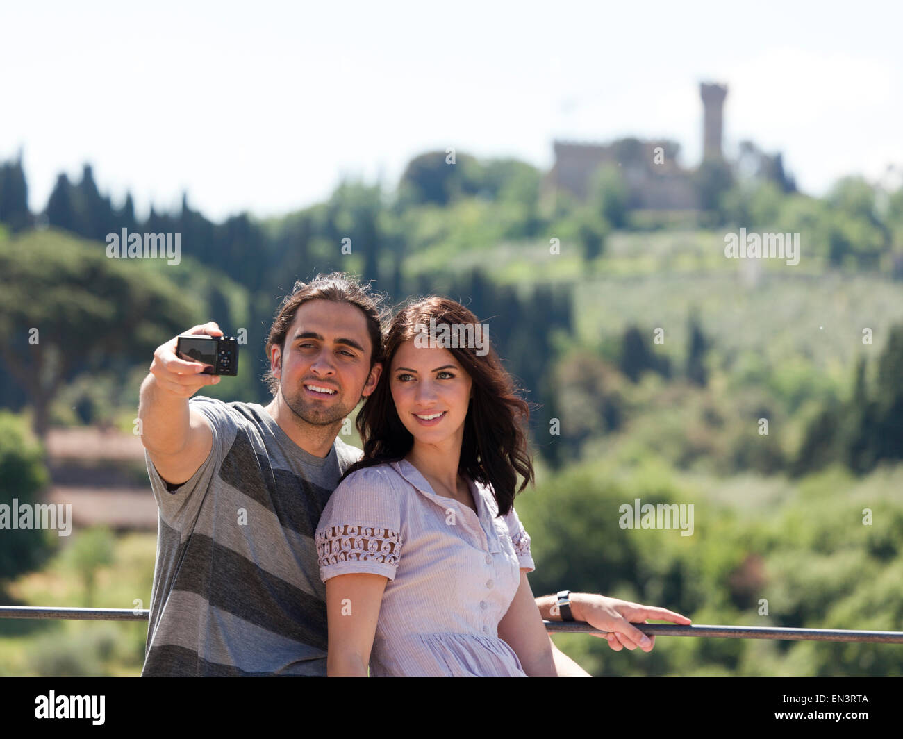 Italy, Florence, Young couple photographing themselves in rural area ...
