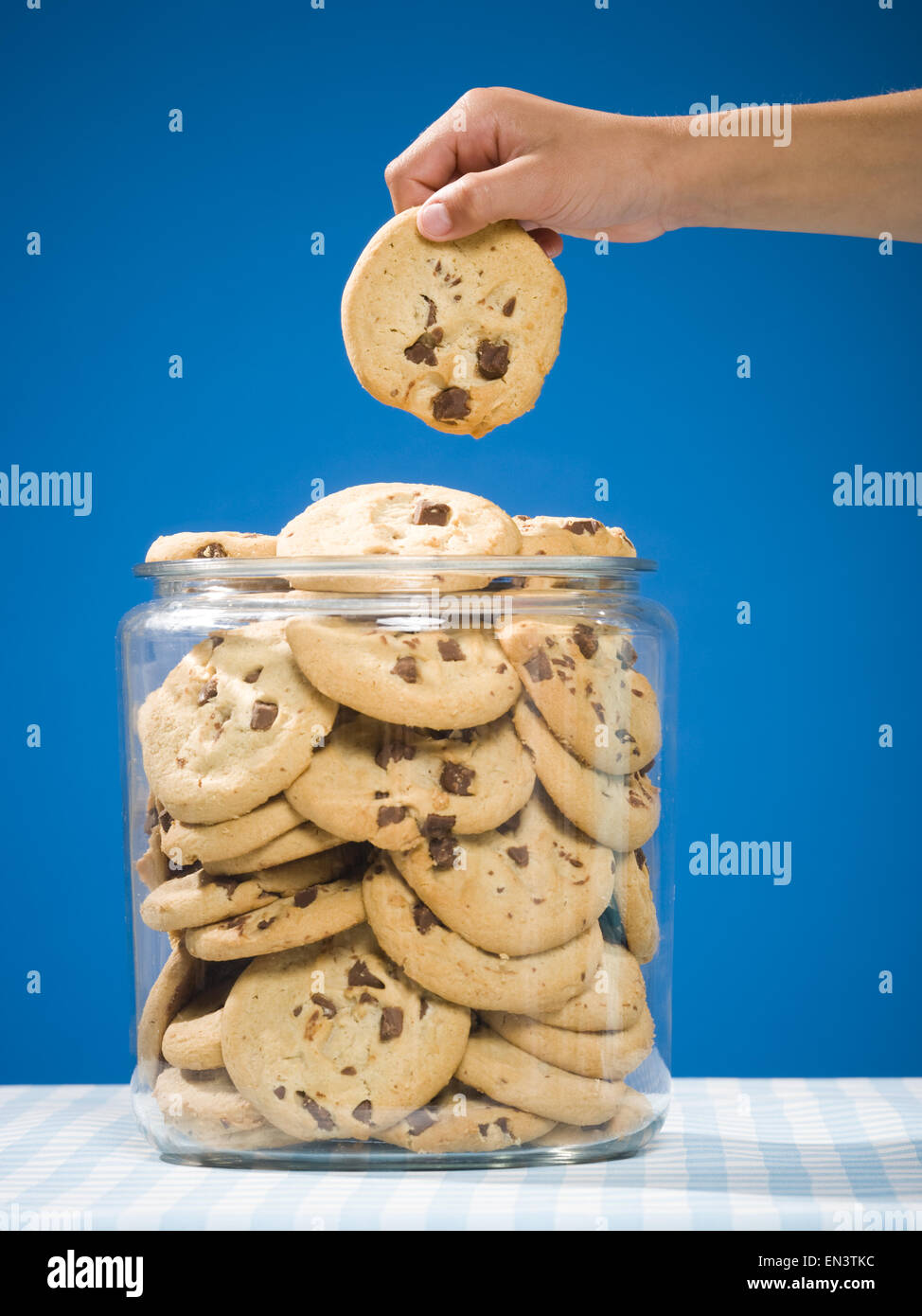 Hand grabbing chocolate chip cookie from jar Stock Photo - Alamy