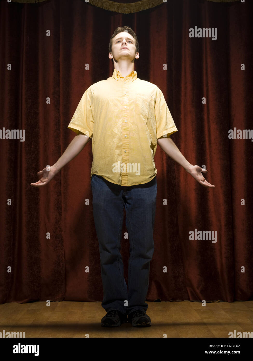 Man standing on stage with arms open Stock Photo - Alamy
