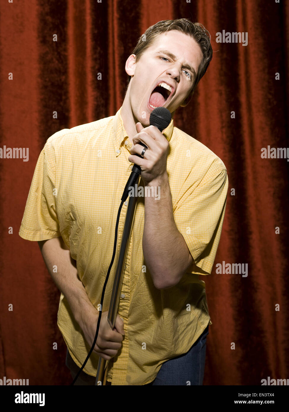 Man yelling or singing into microphone Stock Photo - Alamy