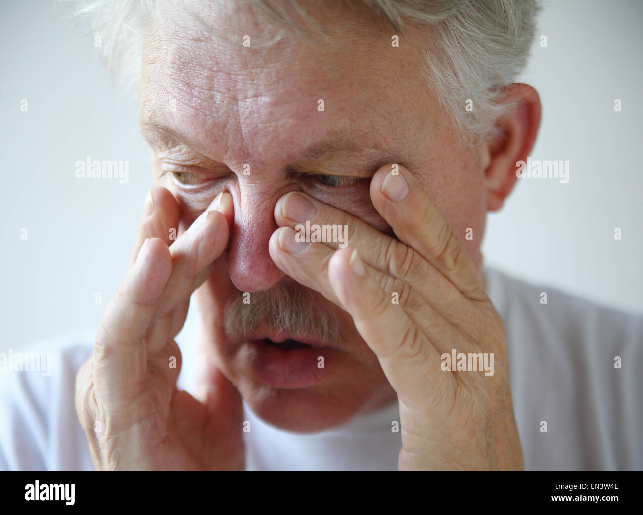 A senior man tries to relieve his stuffy nose Stock Photo - Alamy