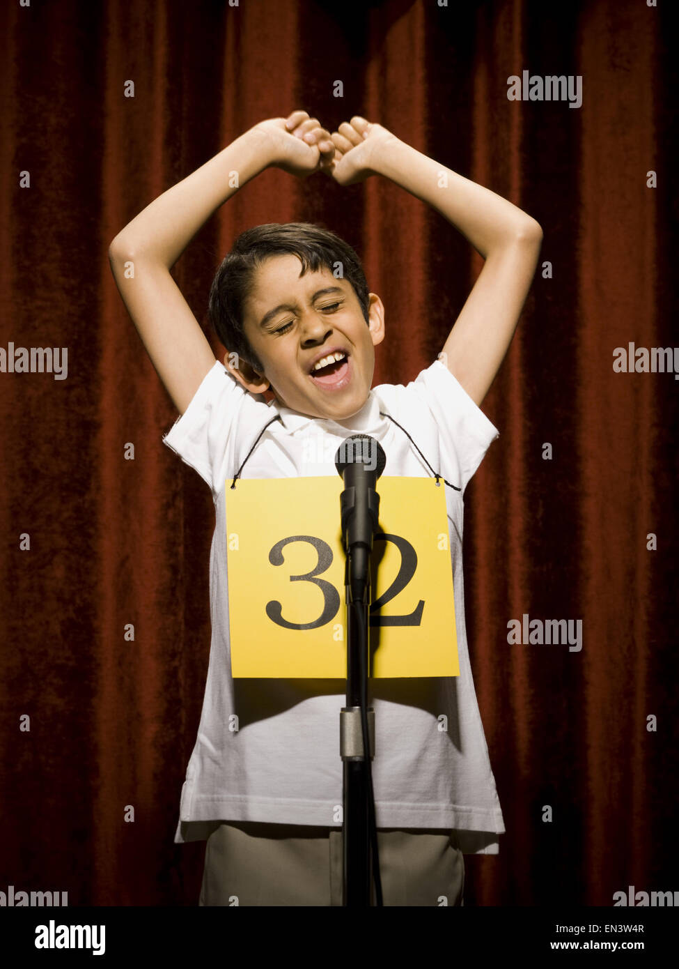 Boy contestant standing at microphone cheering Stock Photo - Alamy