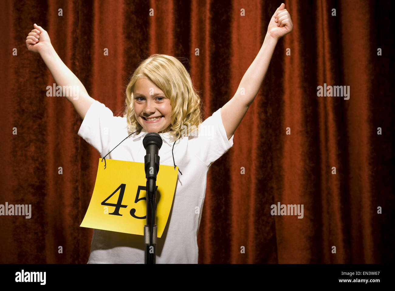 Girl contestant standing at microphone cheering Stock Photo - Alamy