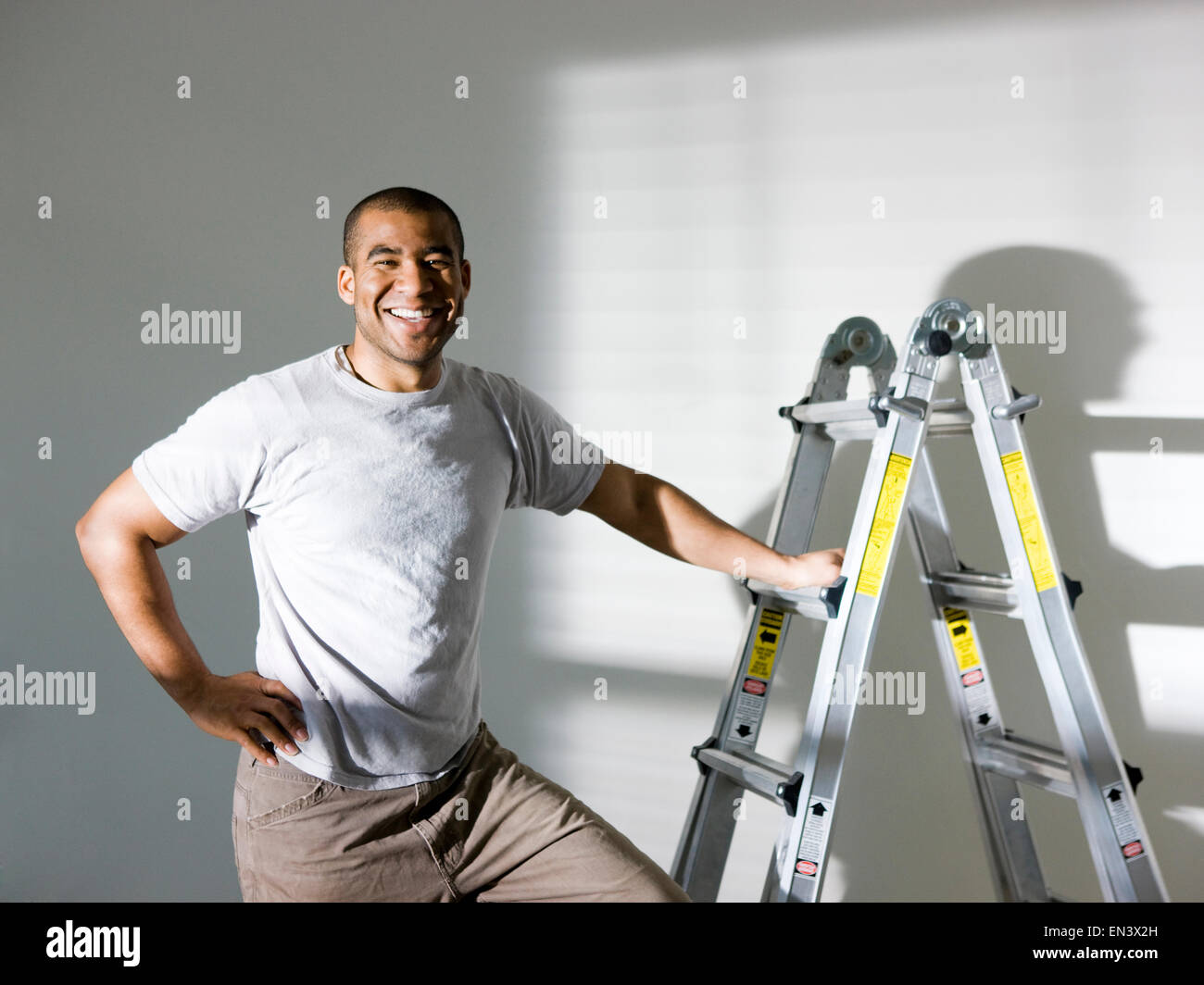 man standing next to a ladder Stock Photo - Alamy