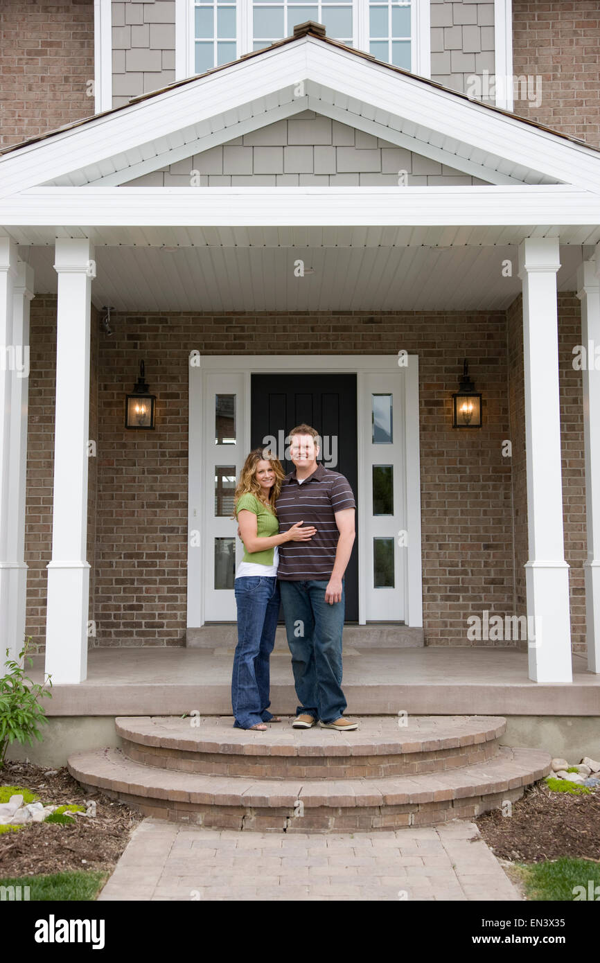 couple standing in front of house Stock Photo - Alamy