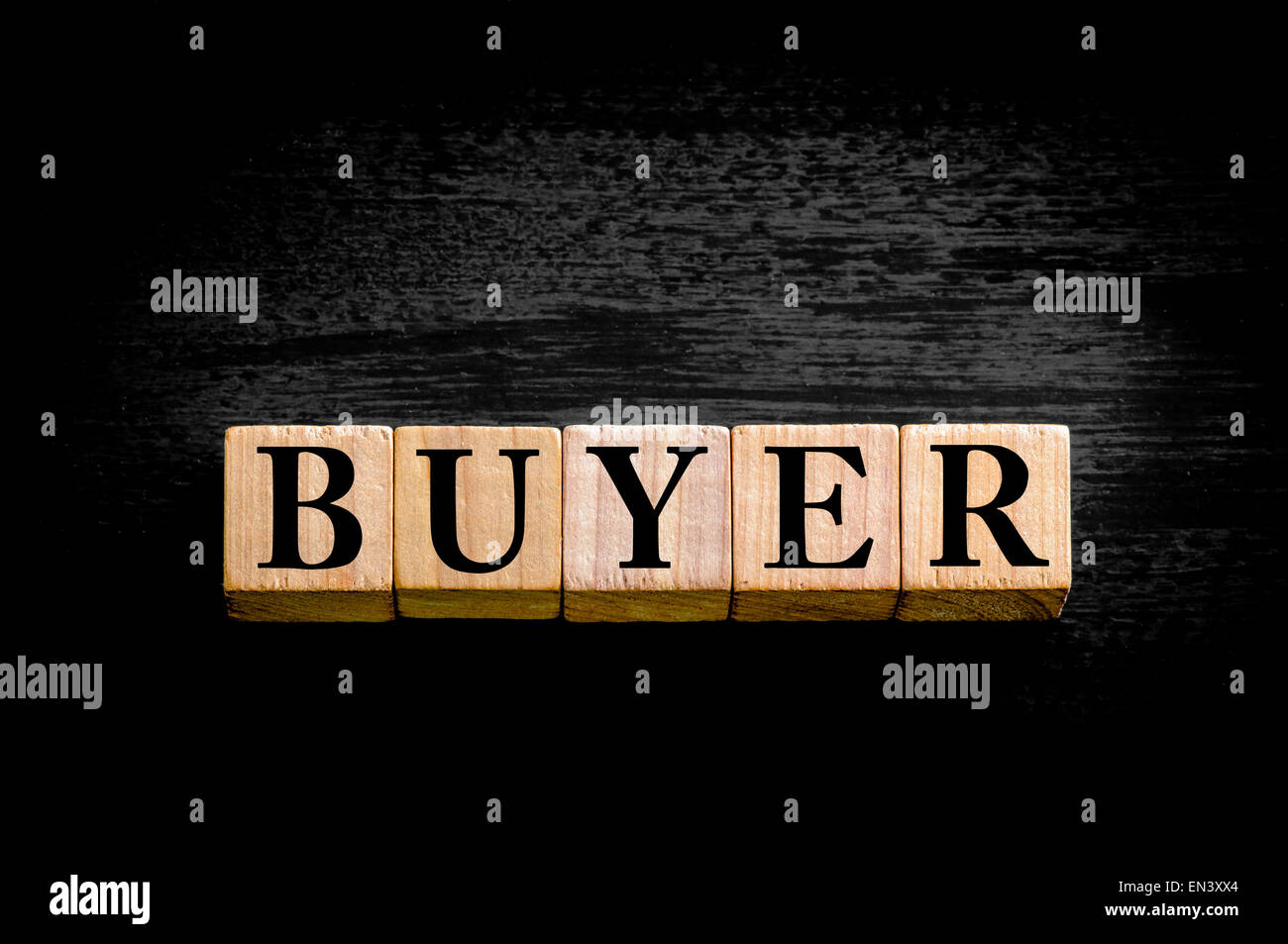 Word BUYER. Wooden small cubes with letters isolated on black ...