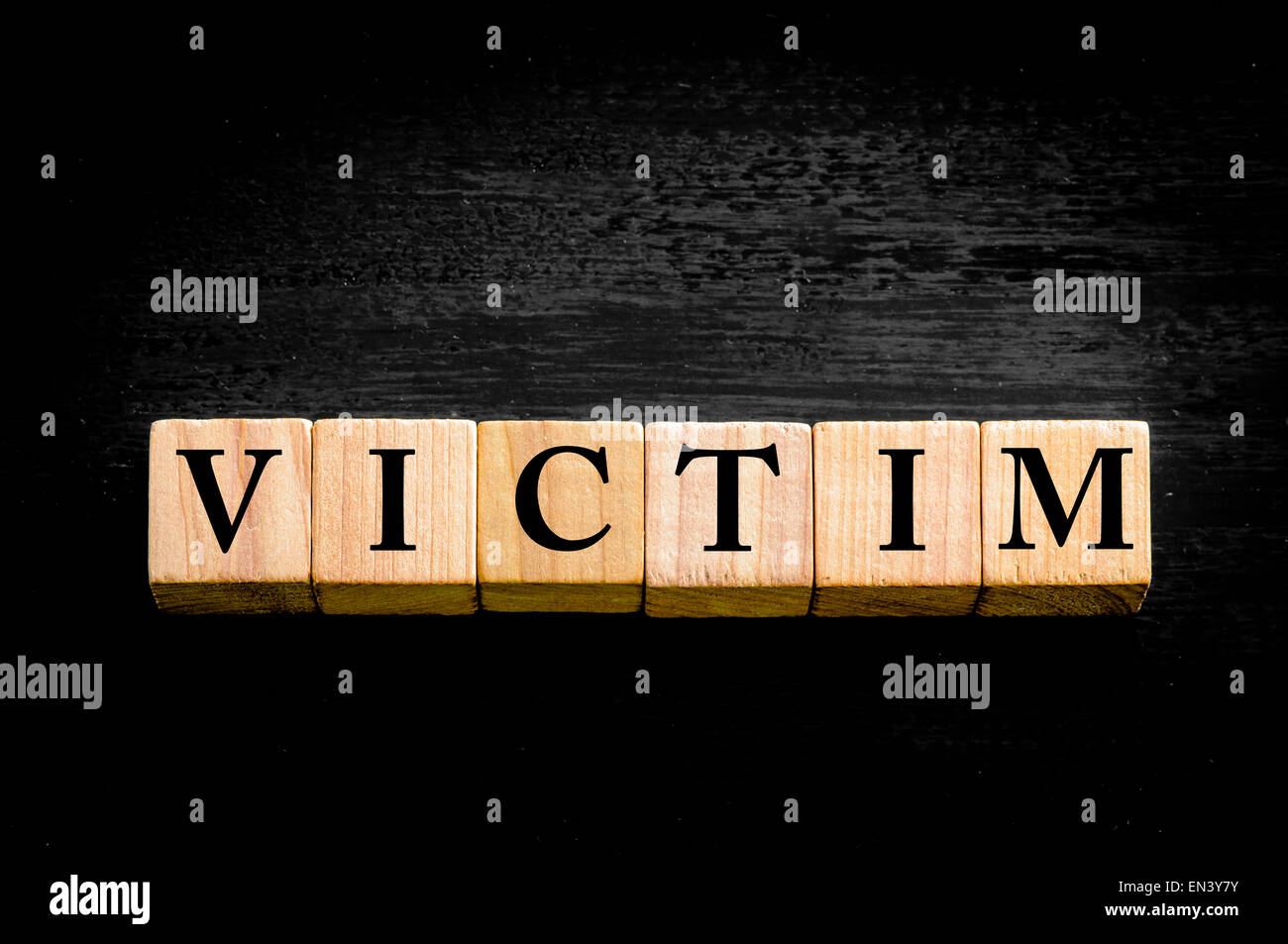 Word VICTIM. Wooden small cubes with letters isolated on black ...