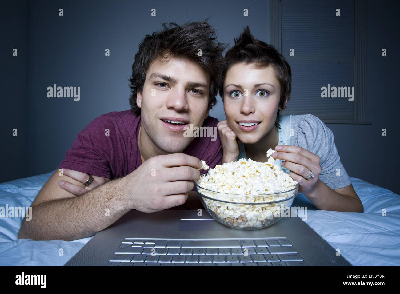 Couple eating popcorn and smiling Stock Photo - Alamy
