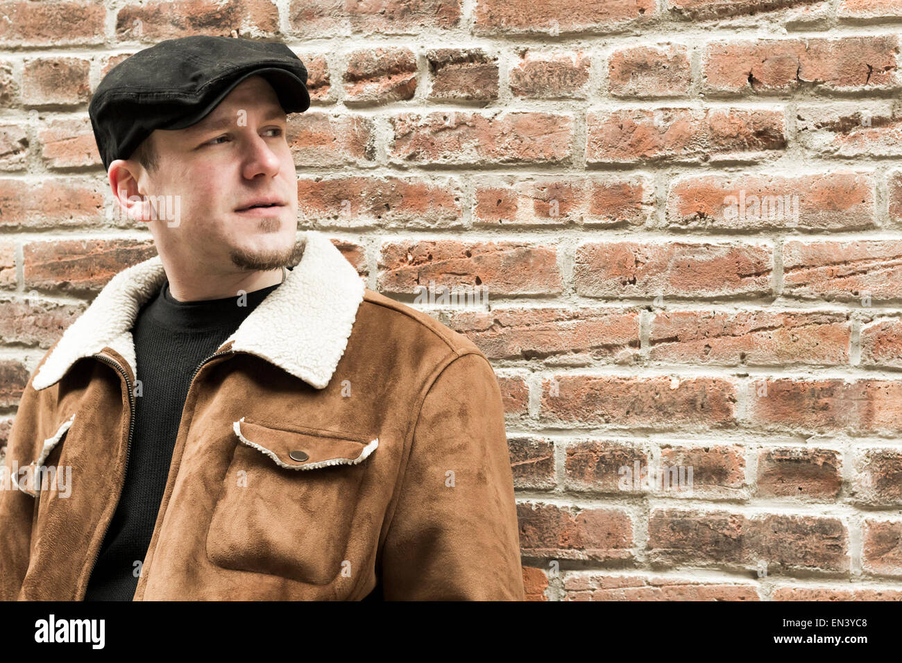 Cool guy rocks an aviator jacket and newsboy cap as he takes a moment ...