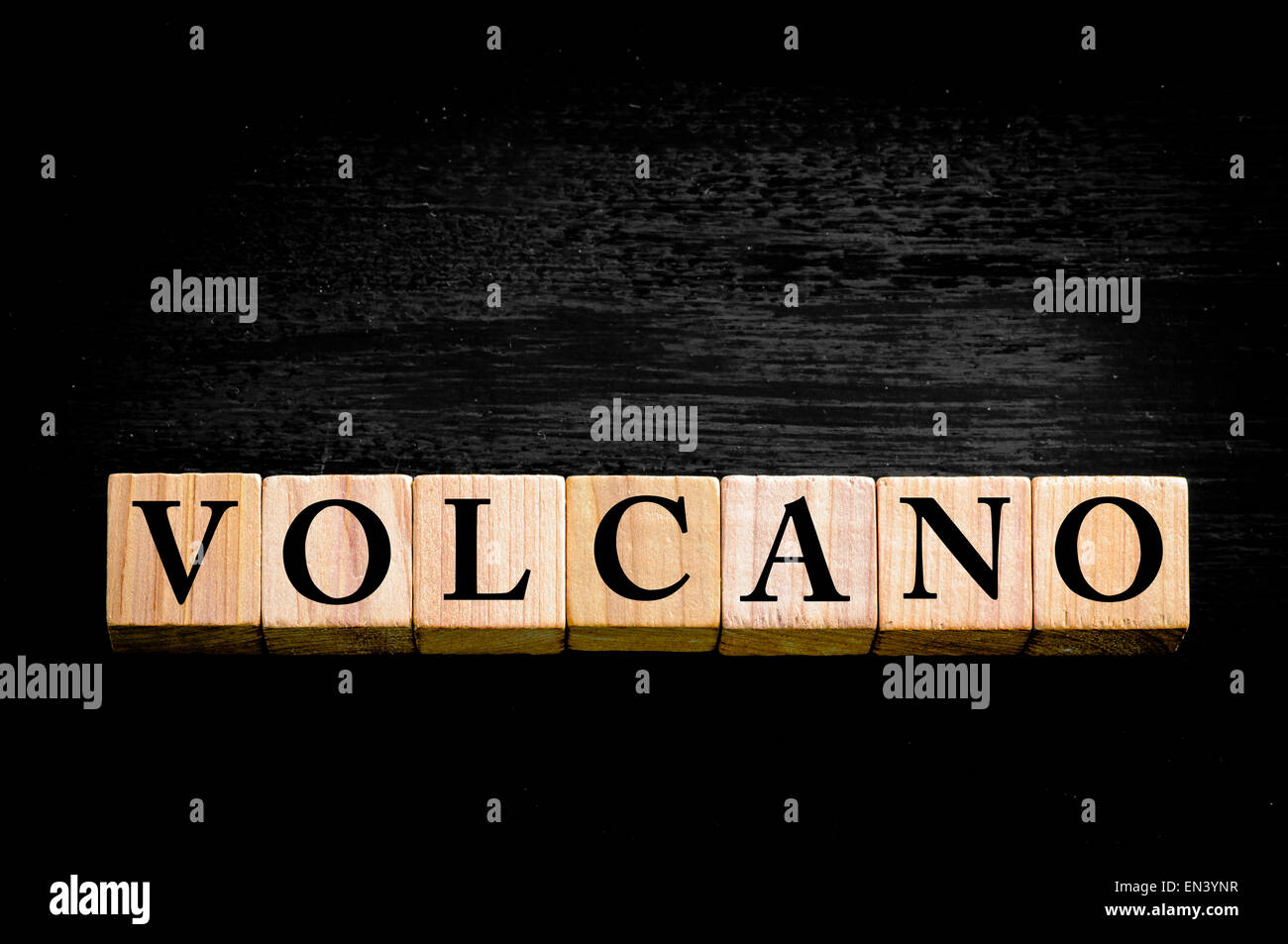Word VOLCANO. Wooden small cubes with letters isolated on black ...