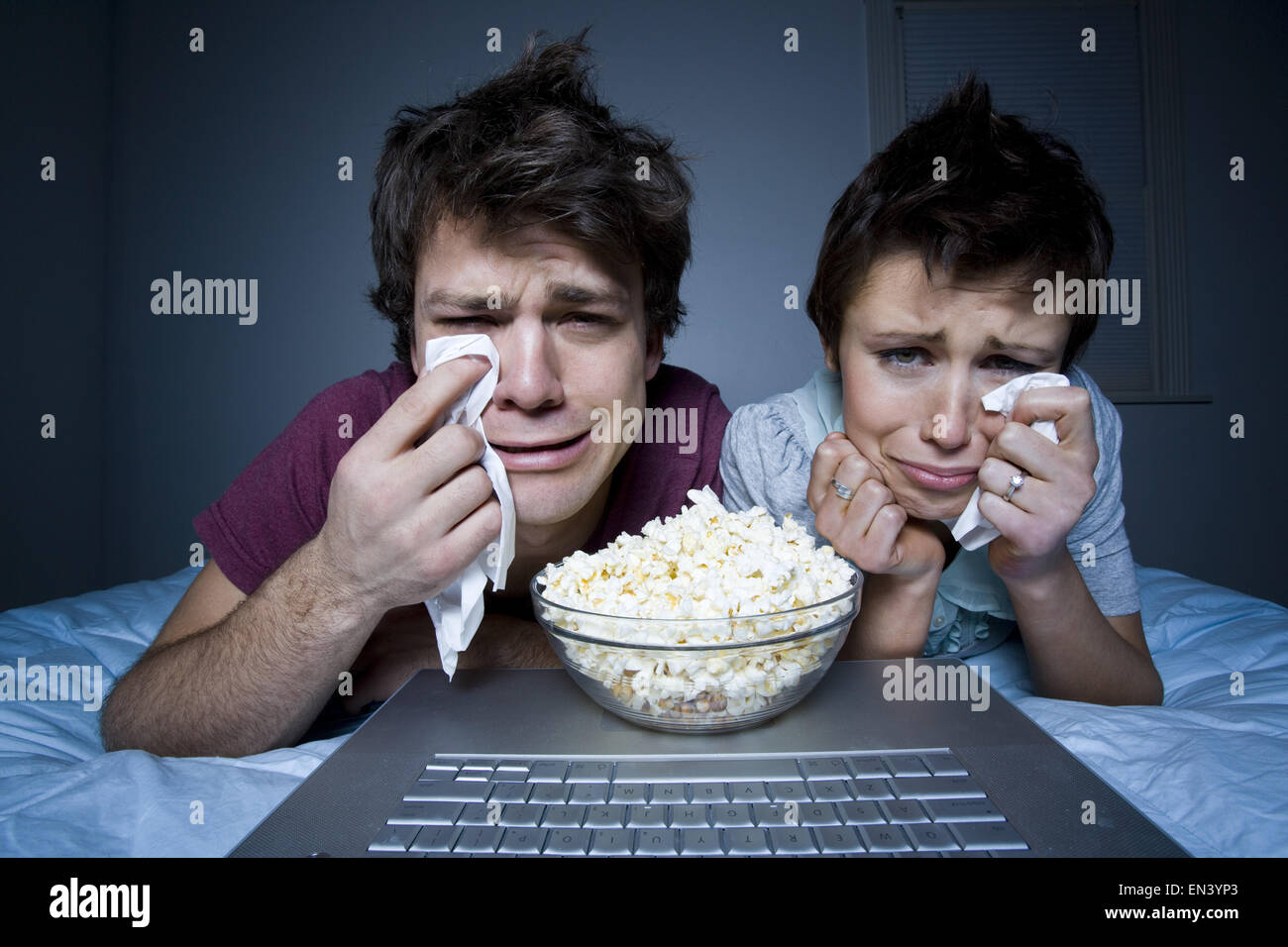 Couple crying with tissue and bowl of popcorn Stock Photo - Alamy
