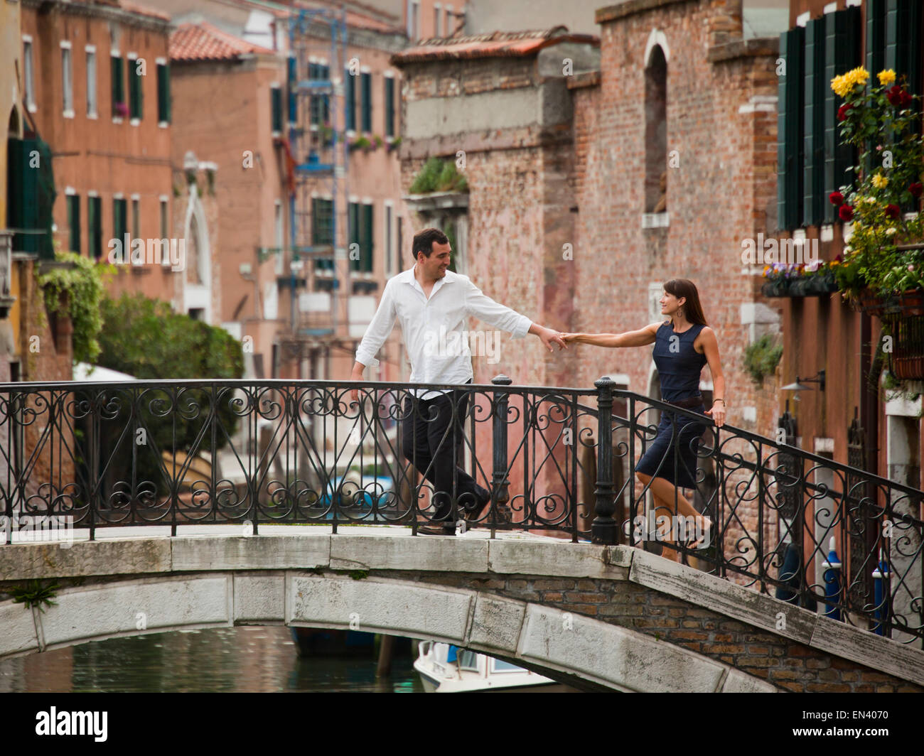 Italy, Venice, Romantic couple walking on footbridge over canal Stock ...