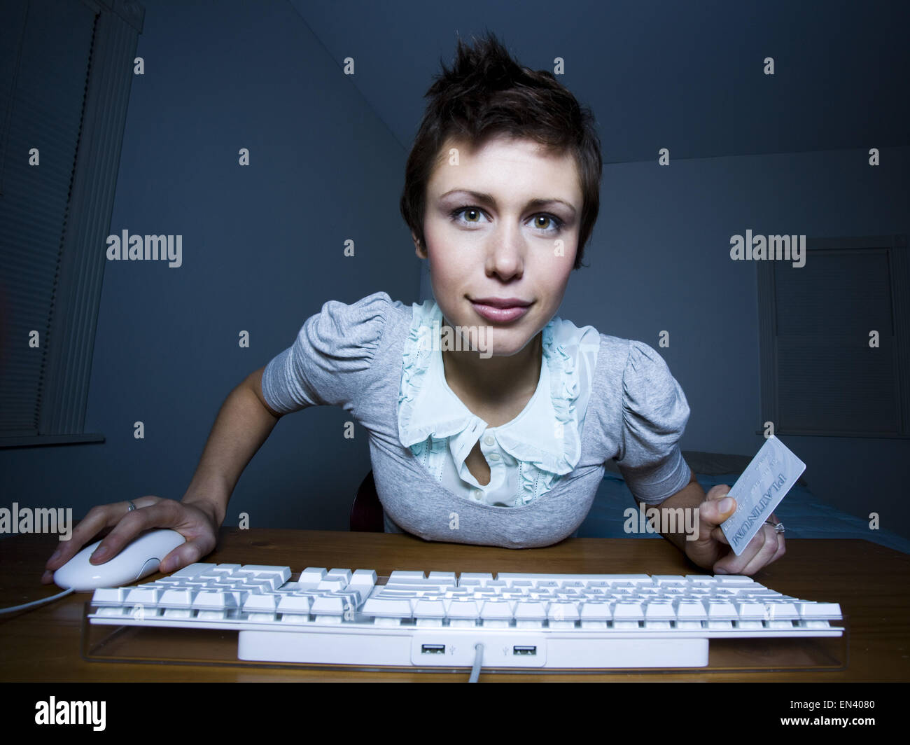 Woman sitting at keyboard with credit card Stock Photo - Alamy
