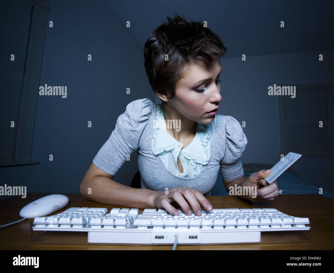 Woman sitting at keyboard with credit card Stock Photo - Alamy
