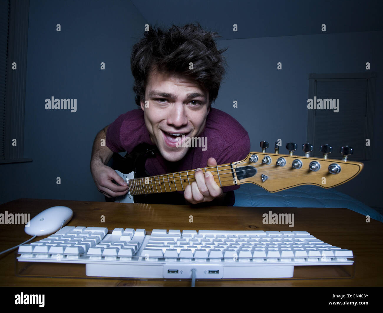 Man at keyboard playing guitar and singing Stock Photo - Alamy