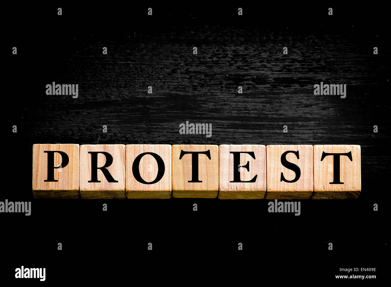 Word PROTEST. Wooden small cubes with letters isolated on black ...