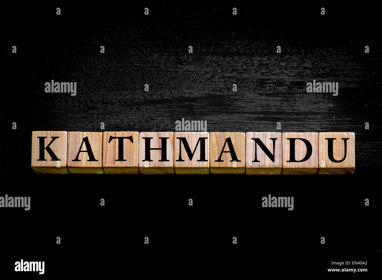 Word KATHMANDU. Wooden small cubes with letters isolated on black ...