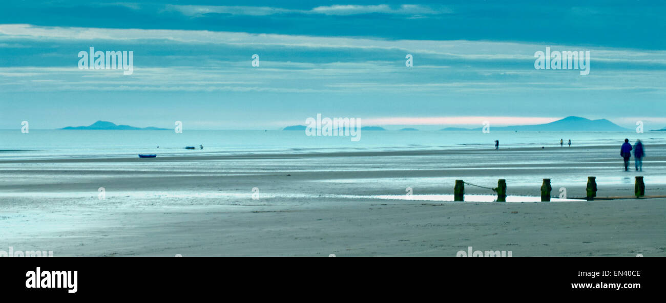 A hazy post-storm scene as people walk on Ynyslas beach in Wales, UK in ...