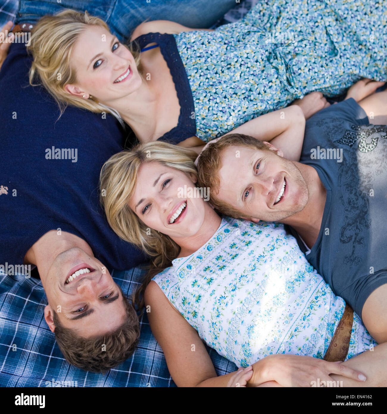 two couples lying on a picnic blanket Stock Photo - Alamy