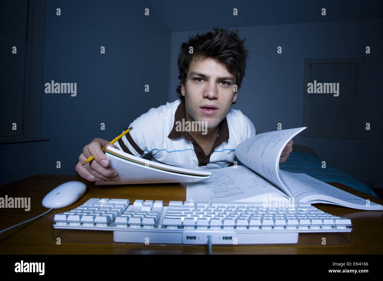 Man at keyboard with pencil and paper taking notes Stock Photo - Alamy