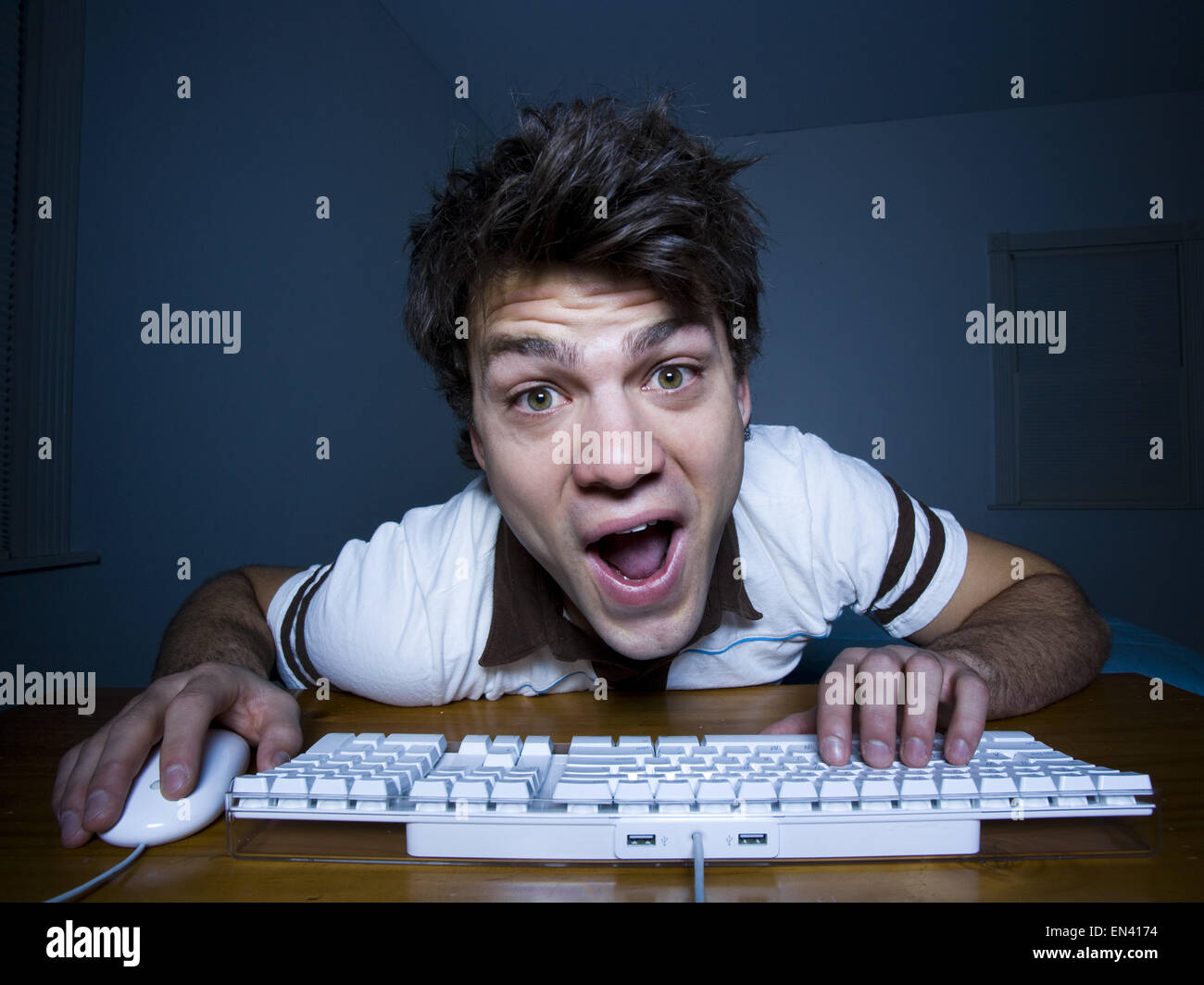 Man typing on keyboard smiling Stock Photo - Alamy