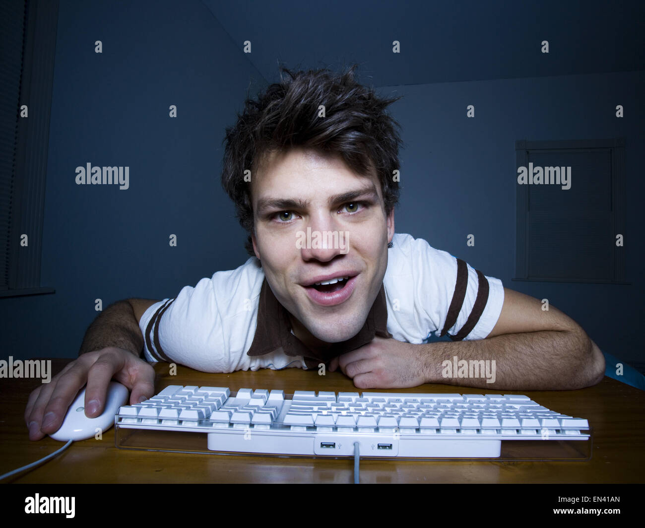 Man typing on keyboard smiling Stock Photo - Alamy