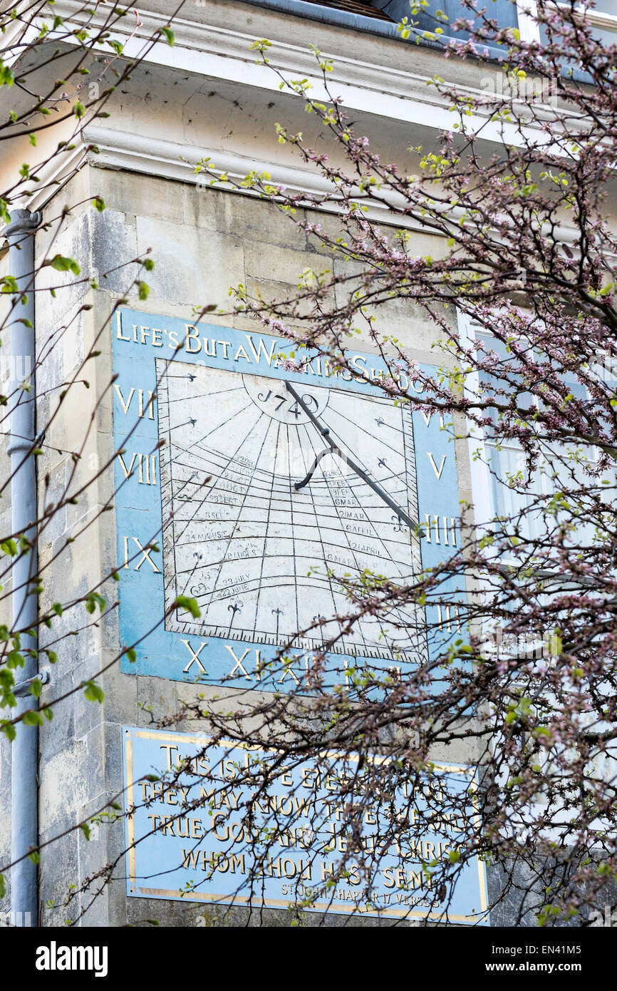 Ornate painted sundial on side of house behind trees Stock Photo - Alamy