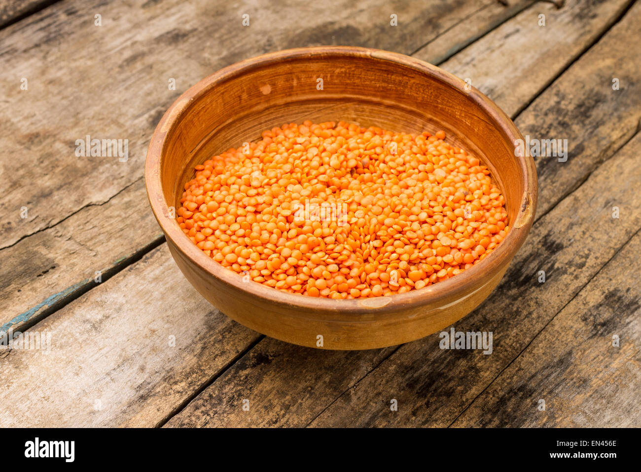 Raw orange lentil in bowl on wooden table. Healthy eating background ...