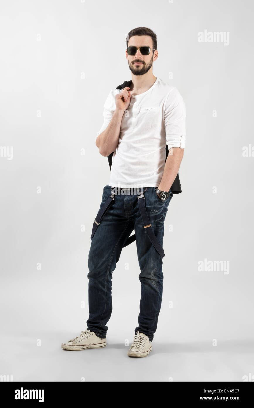 Handsome young model posing holding jacket over his shoulder. Full body ... Handsome young model posing holding jacket over his shoulder. Full body ...
