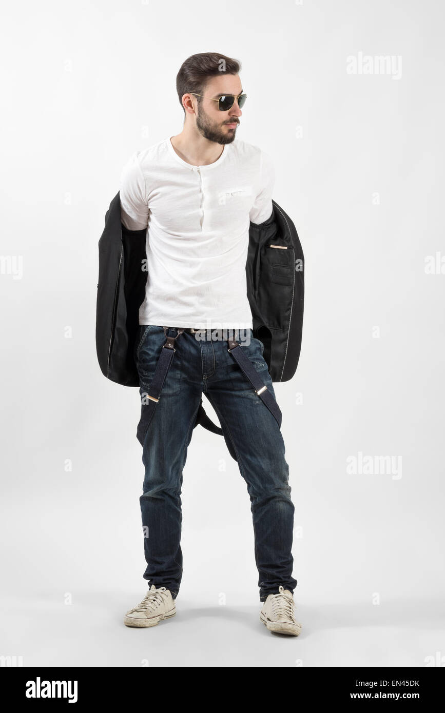 Young handsome fashion model putting on jacket. Full body length ...