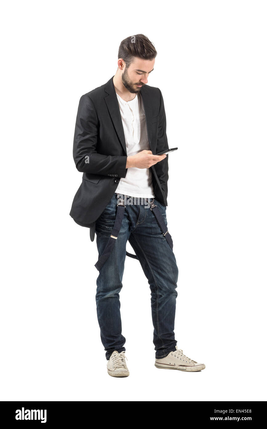 Young fashion model looking down using cellphone device. Full body ...
