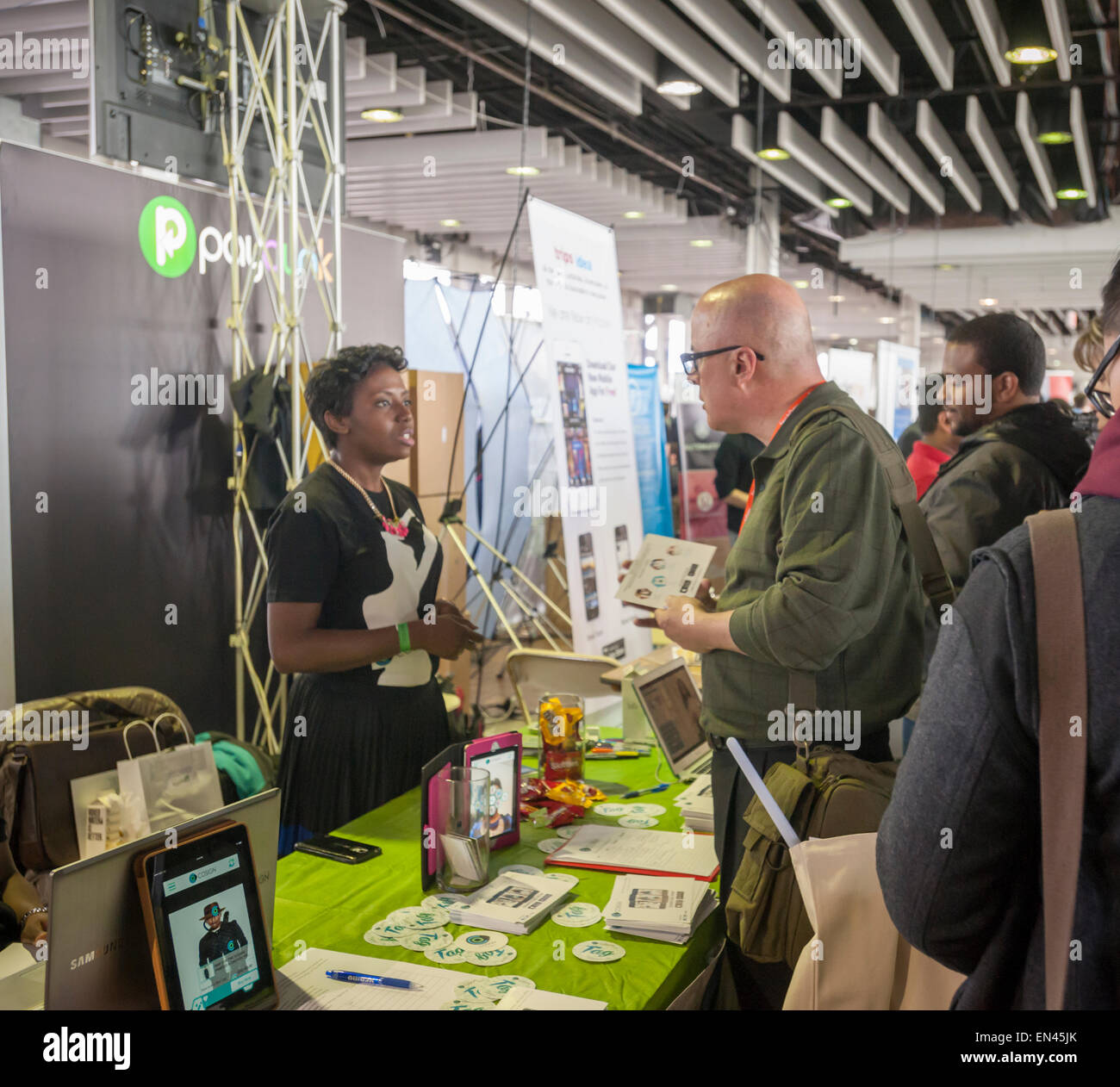 A visitor speaks with a Paydunk employee at the TechDay New York event on Thursday, April 23 ...