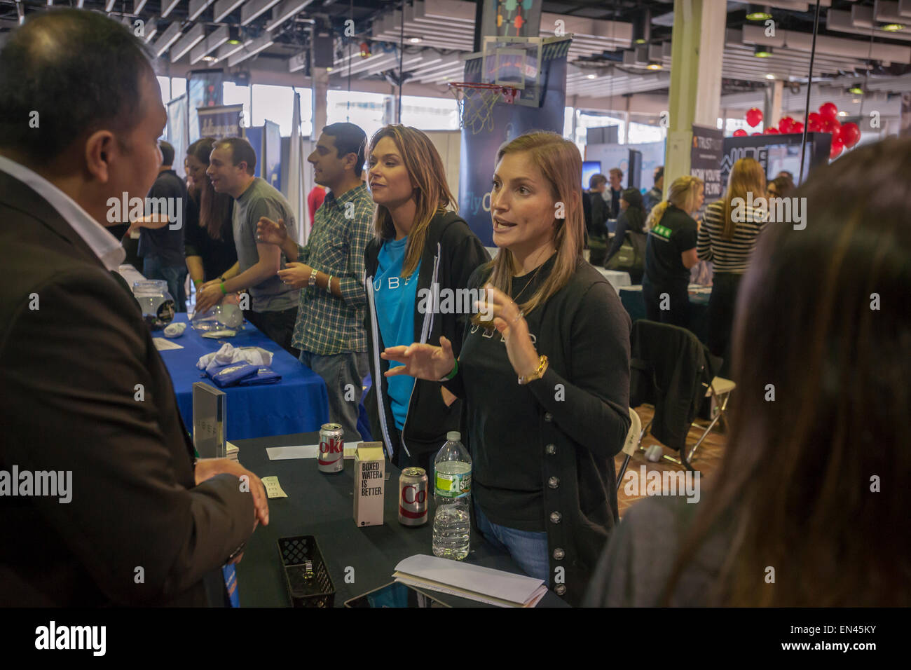 An Uber employee speaks with a visitor at the TechDay New York event on ...